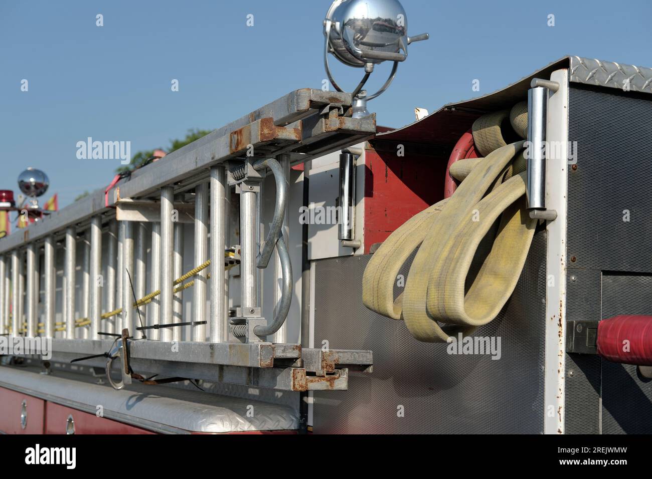 Hose and ladder stored on the side of a red fire engine Stock Photo - Alamy