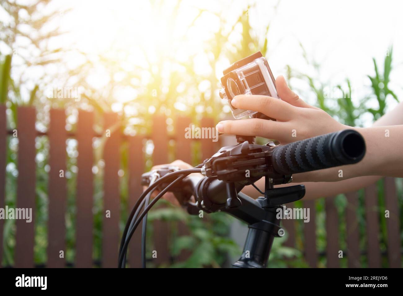 A woman's hand adjusts a digital camera mounted on the handlebars of a ...