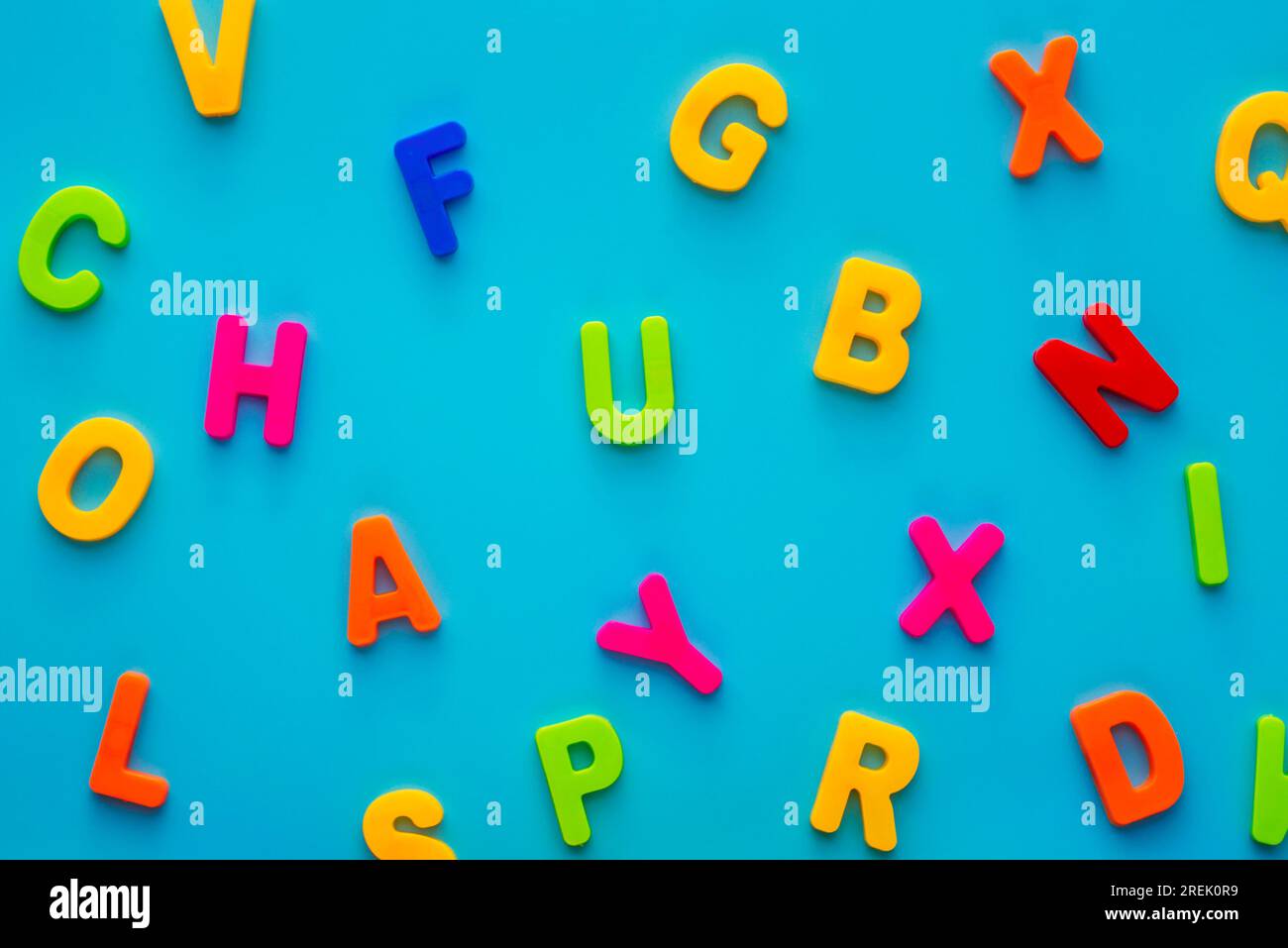 The letters of the alphabet are scattered randomly on a blue background ...