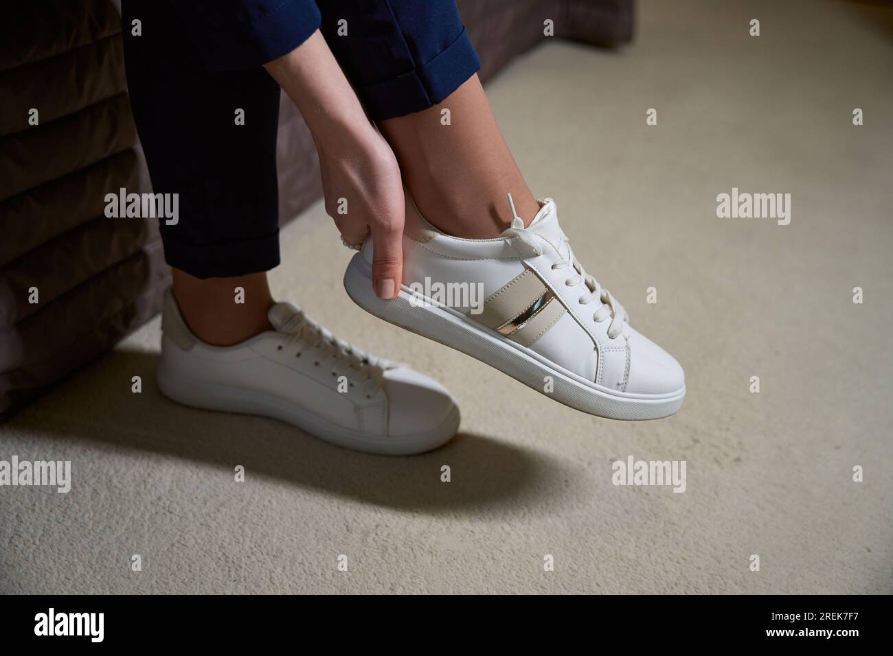 Young female taking off sneakers in the hotel Stock Photo - Alamy