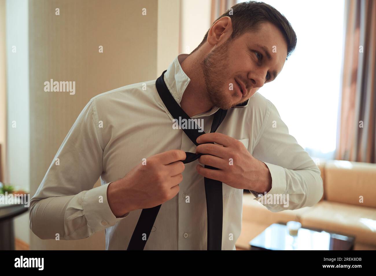 Man getting dressed before job and talking on phone Stock Photo - Alamy