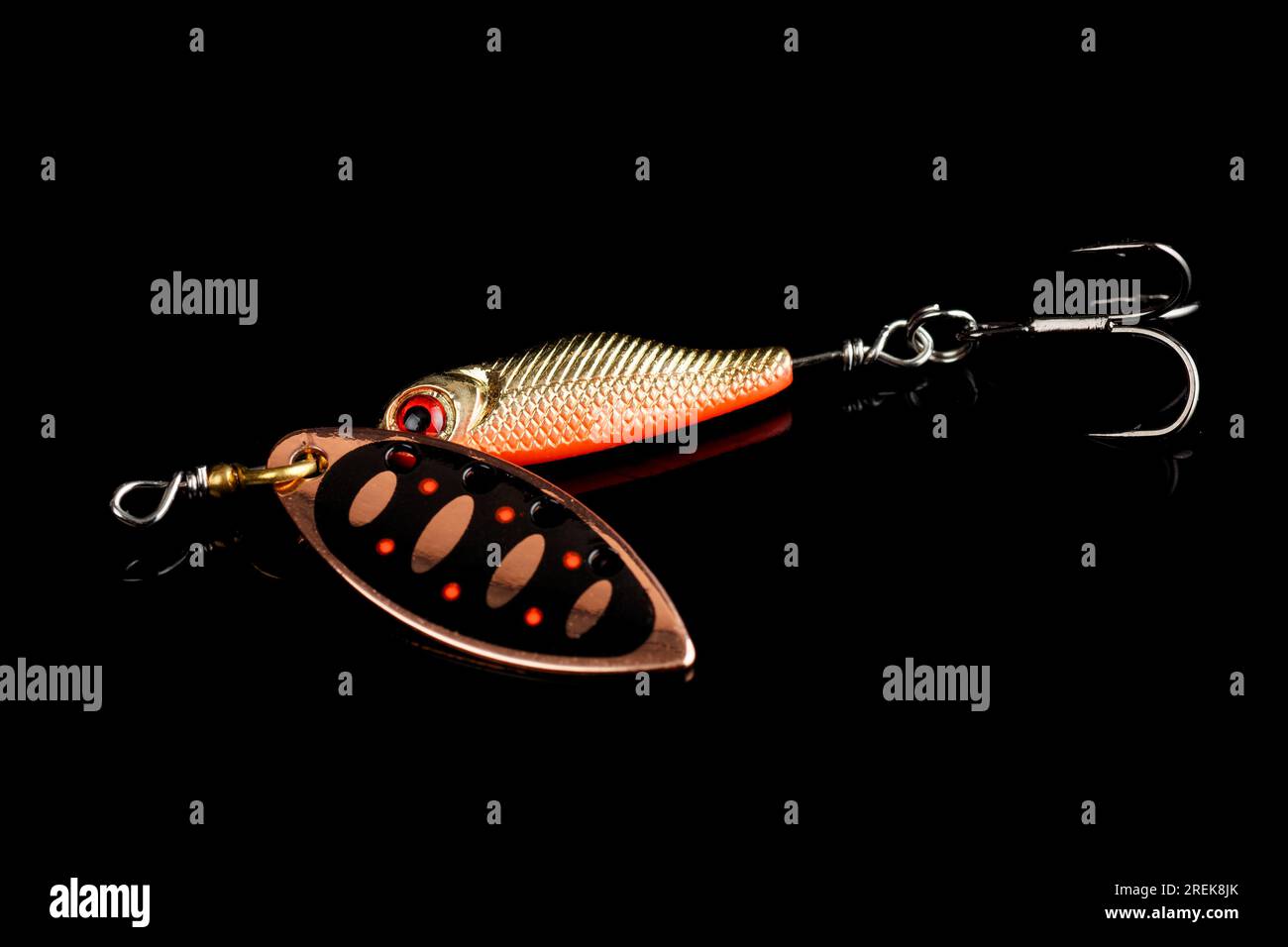 Copper red and black spinner, artificial metal lure, on black ...