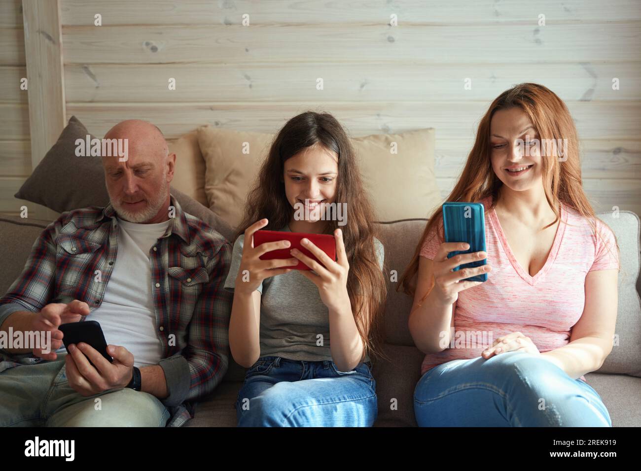 Contemporary family viewing something on their smartphones at home ...
