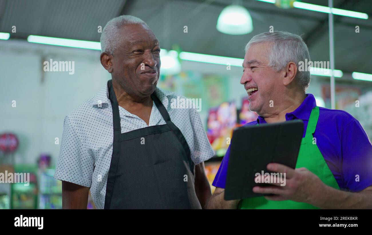 Happy senior colleagues of supermarket laughing and smiling, candid ...