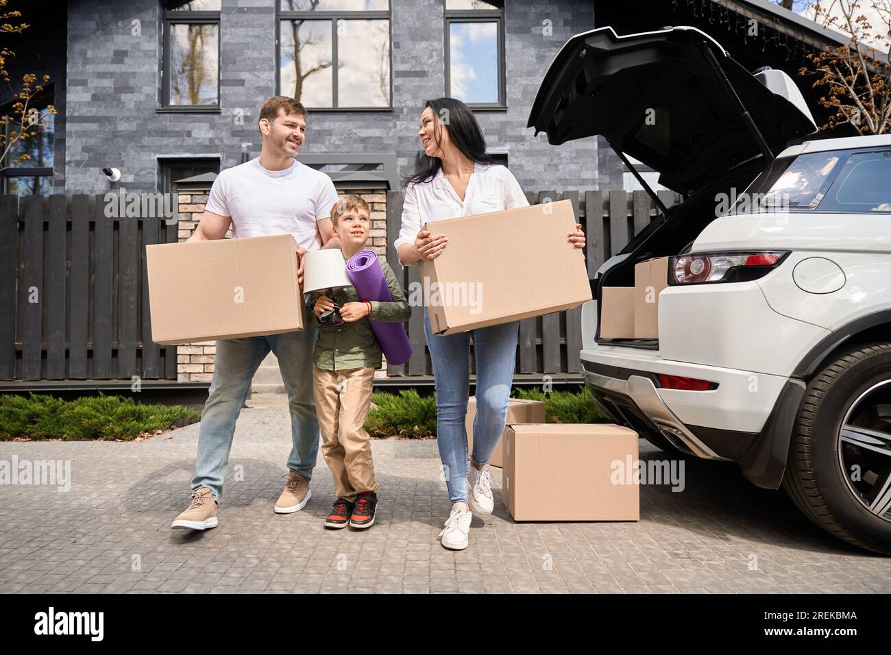 Caucasian family with a child happily brings boxes Stock Photo - Alamy