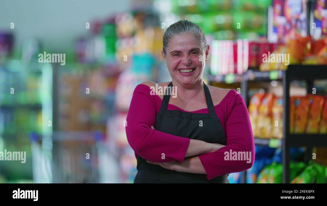 Joyful Female Grocery Store Worker Smiling at Camera with arms crossed ...