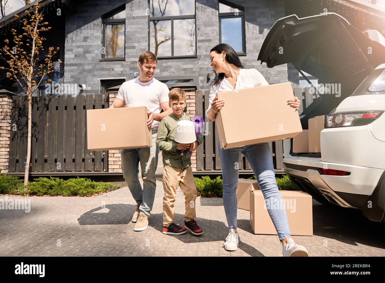Caucasian family brings boxes into the house Stock Photo - Alamy