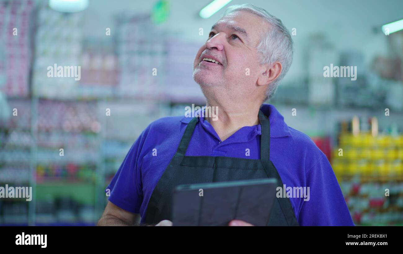 Male Caucasian Senior Manager of Grocery Store Using Tablet Device to ...