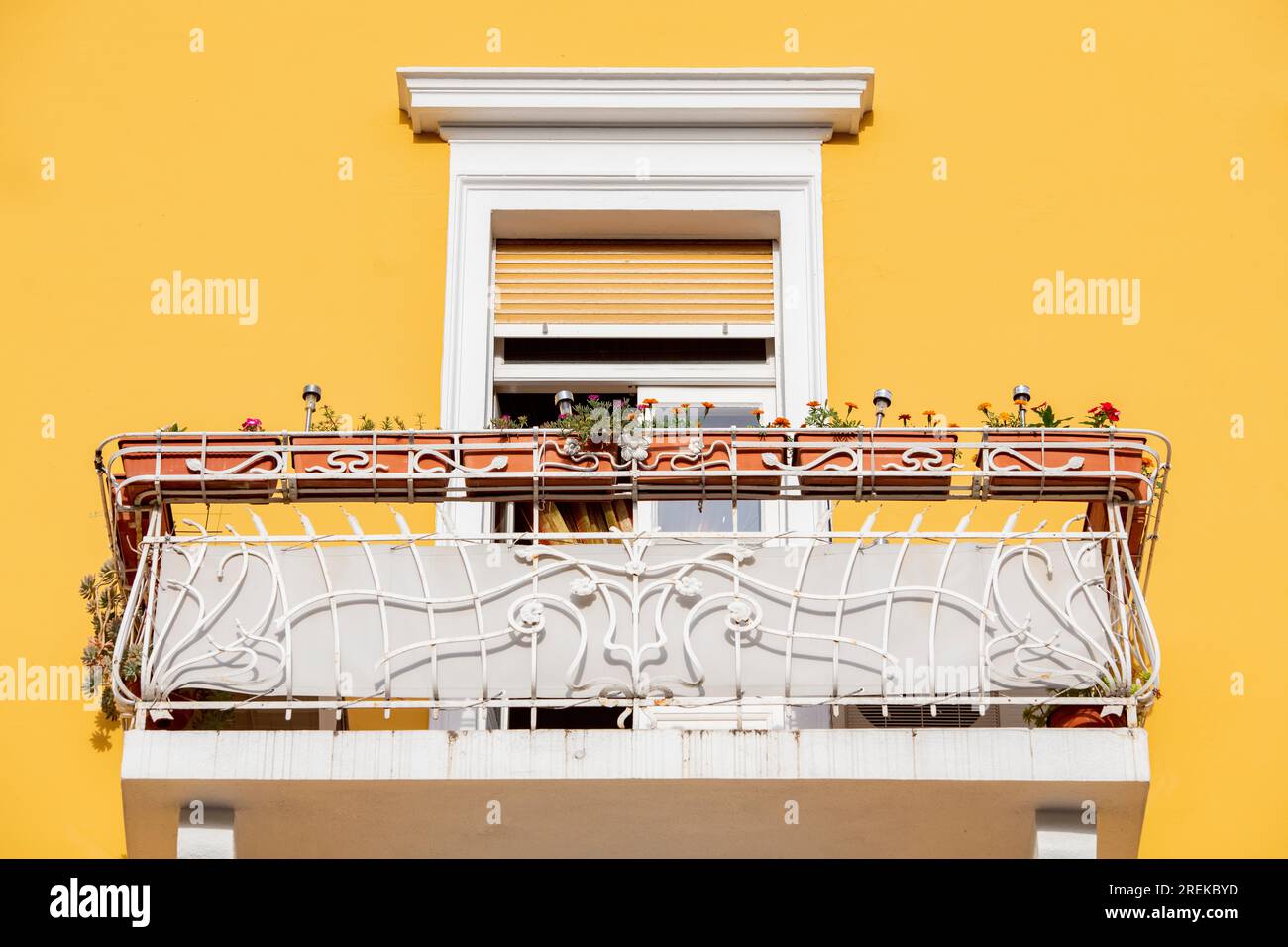 beautiful ornate balcony made from wrought iron on a yellow painted ...