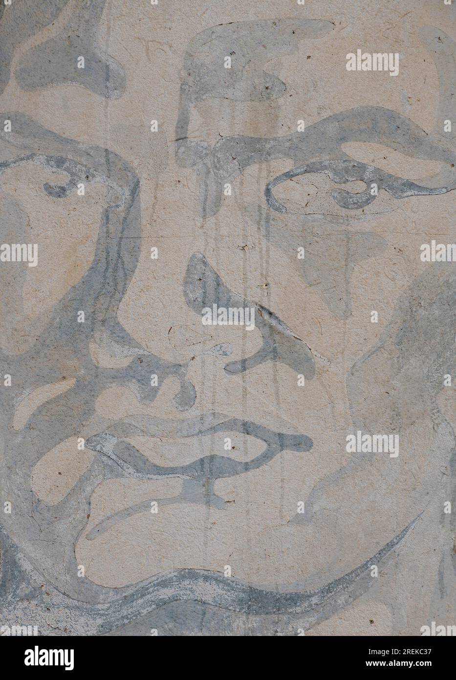 hard looking tough face of a man painted on a wall as street art in ...