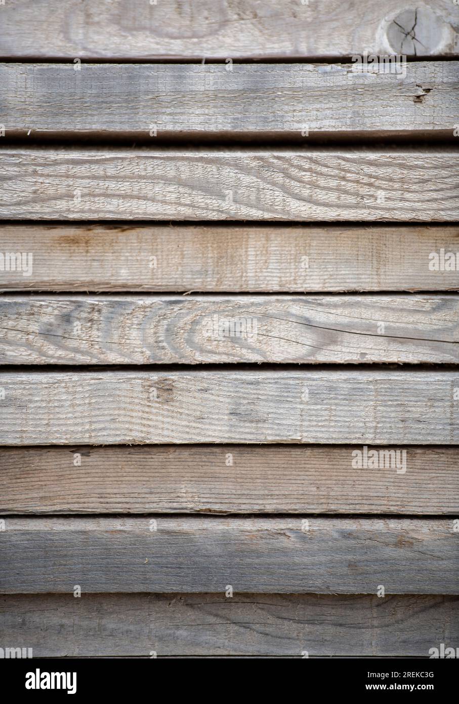 row of wooden planks forming a fence with different grains and patterns ...