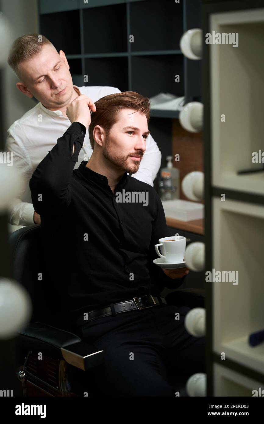 Stylish male client sitting in hair salon Stock Photo - Alamy