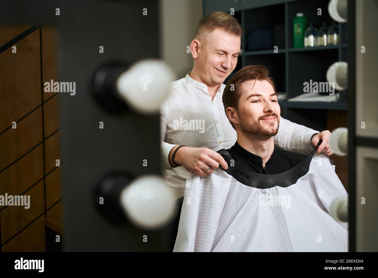 Diligent barber serving male client in modern salon Stock Photo - Alamy