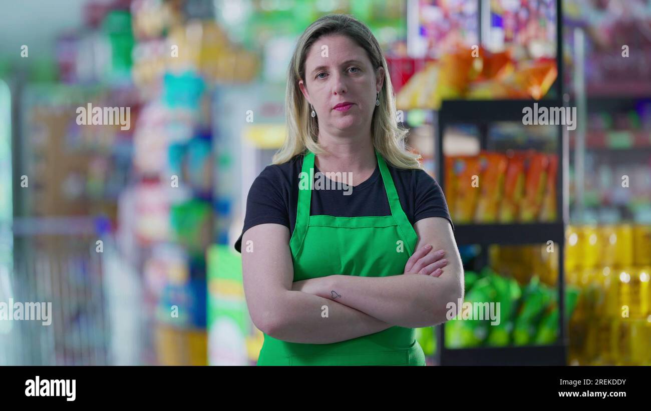Female staff worker of Supermarket crossing arms posing for camera ...