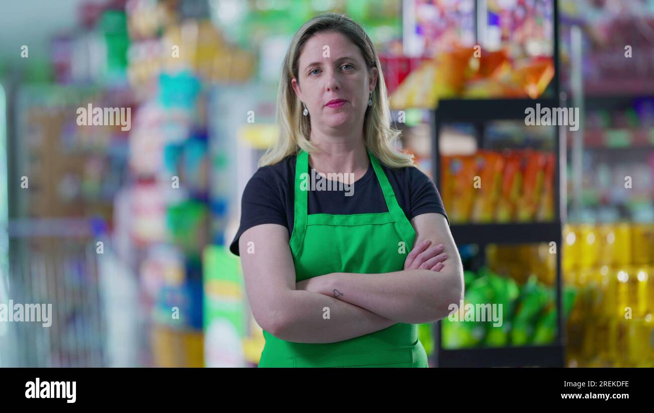 Female staff worker of Supermarket crossing arms posing for camera ...