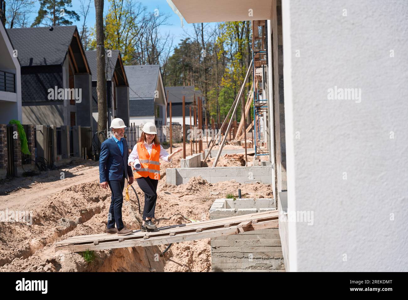 Woman architect welcoming male contractor, showing house under ...