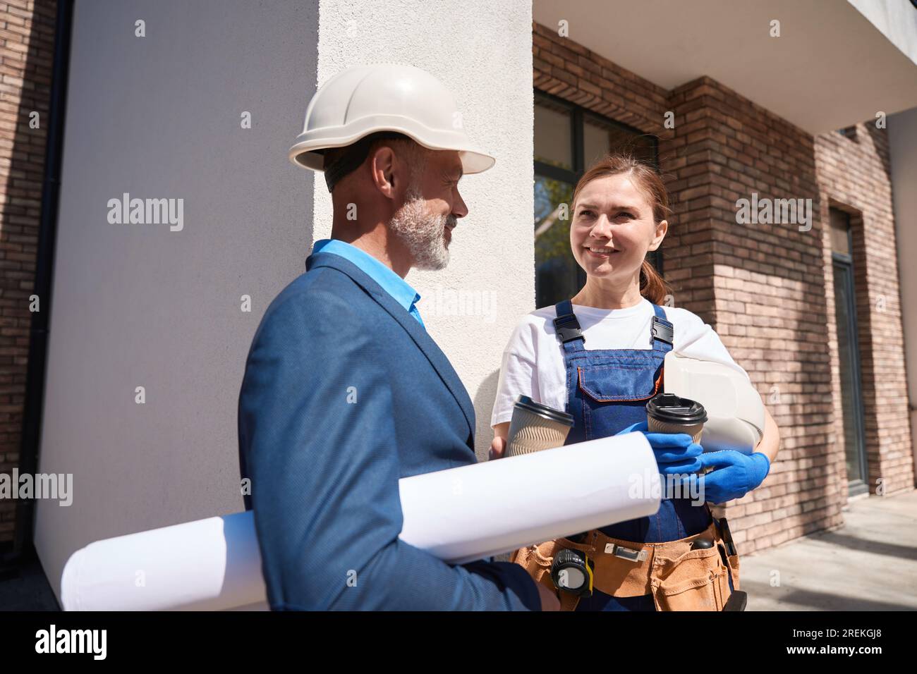 Male architect talking to woman building engineer during coffee break ...