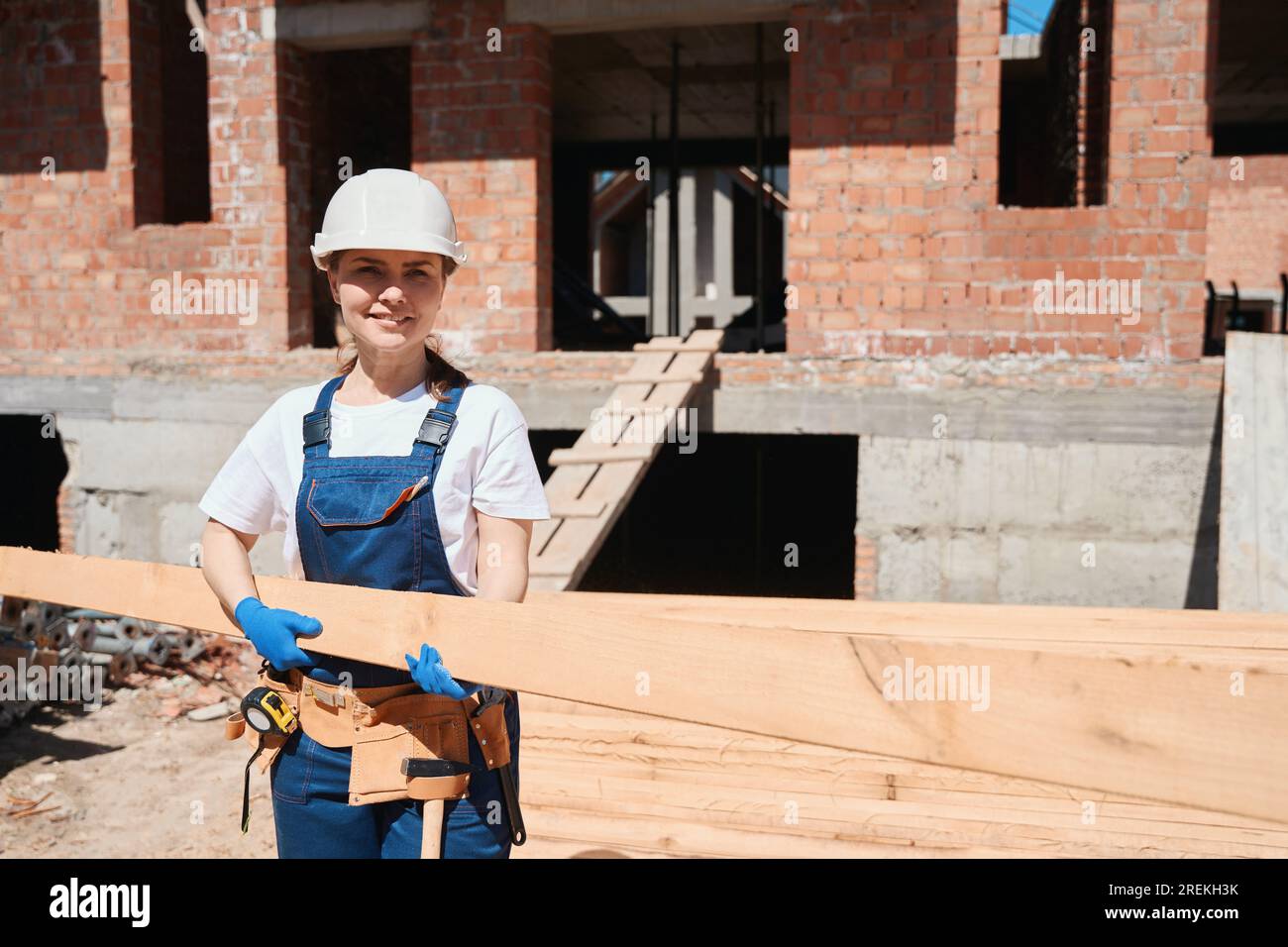 Woman woodworker holding long beam, choosing proper material Stock ...
