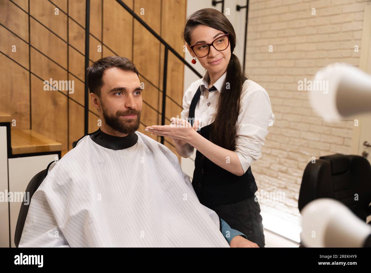 Barber female works with a client in a modern barbershop Stock Photo ...