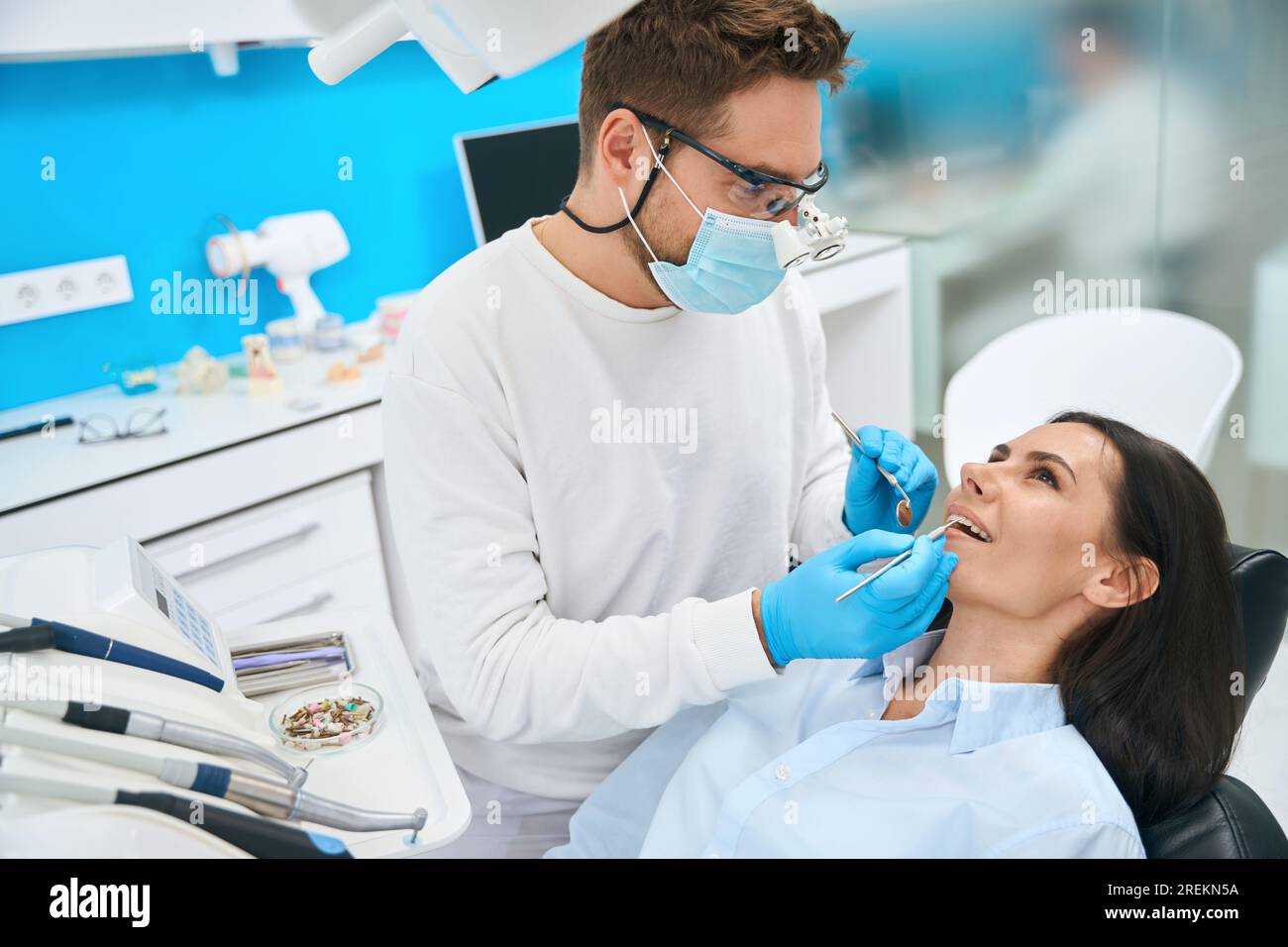 Professional dentist using mouth mirror and sickle probe to check teeth ...