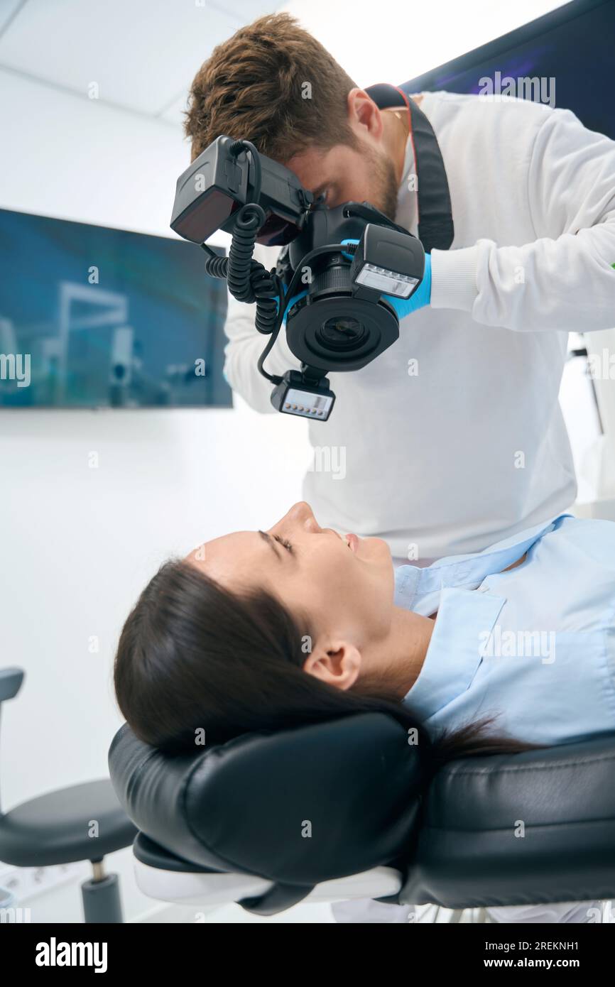 Stomatologist using professional portable x-ray camera to make teeth ...