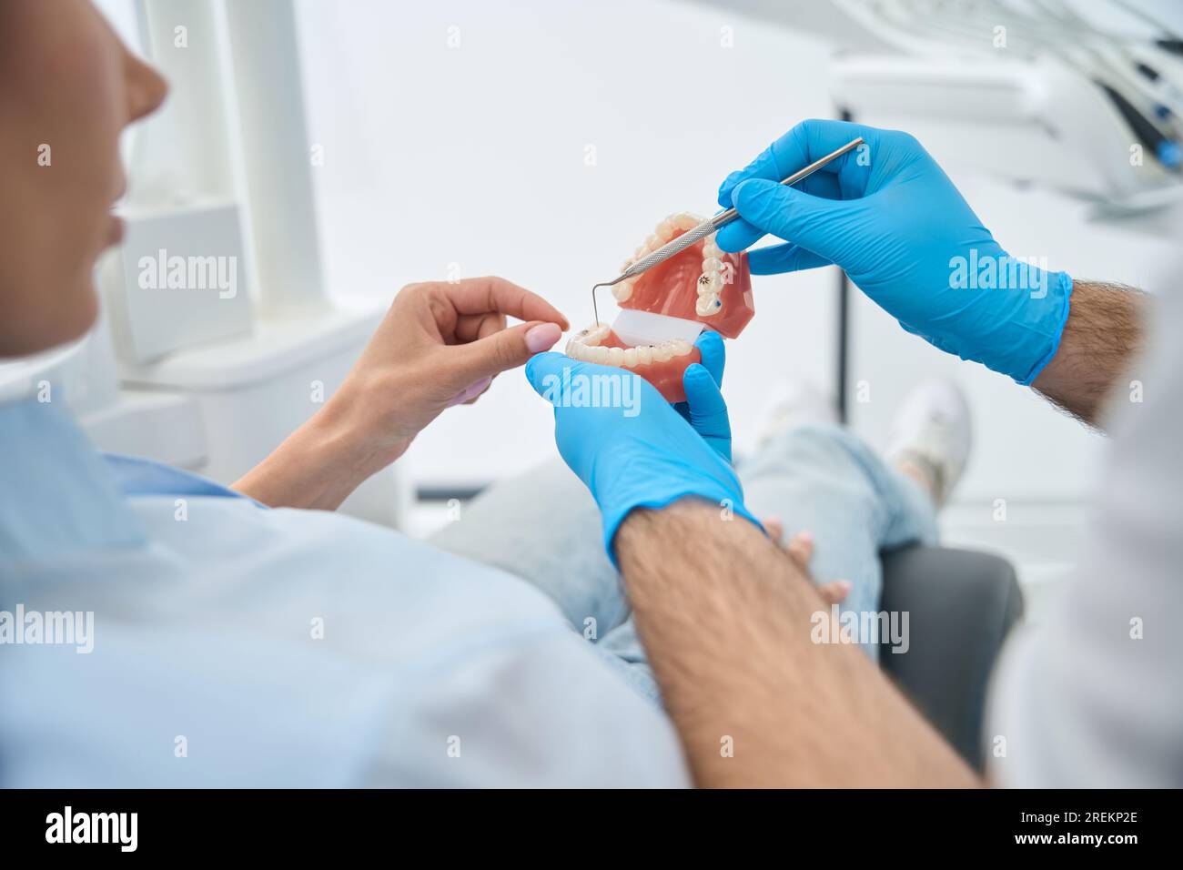 Dental technician using 3d teeth model to show to client problem places ...