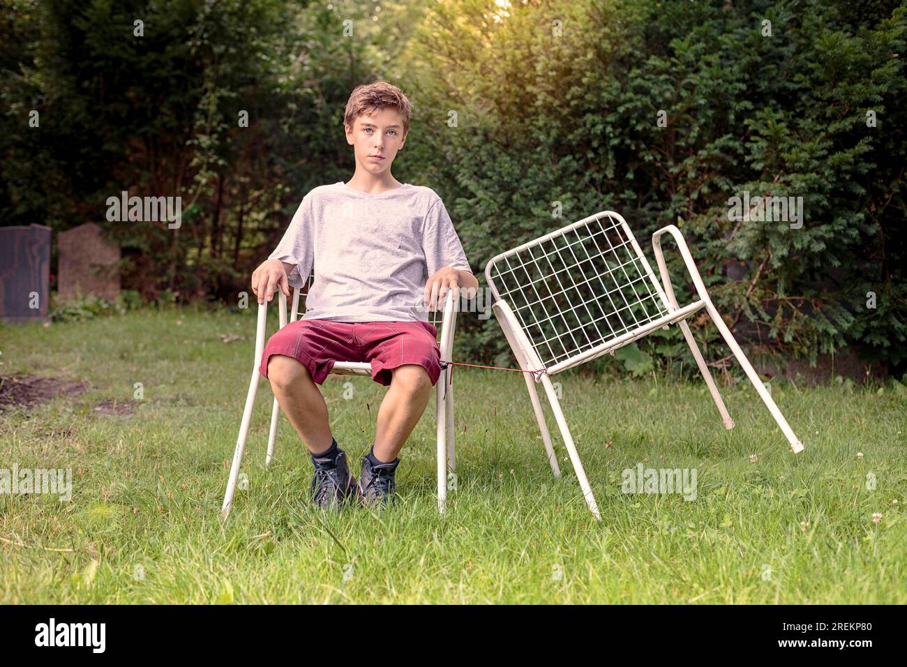 Lonely teenage boy with two chairs Stock Photo - Alamy