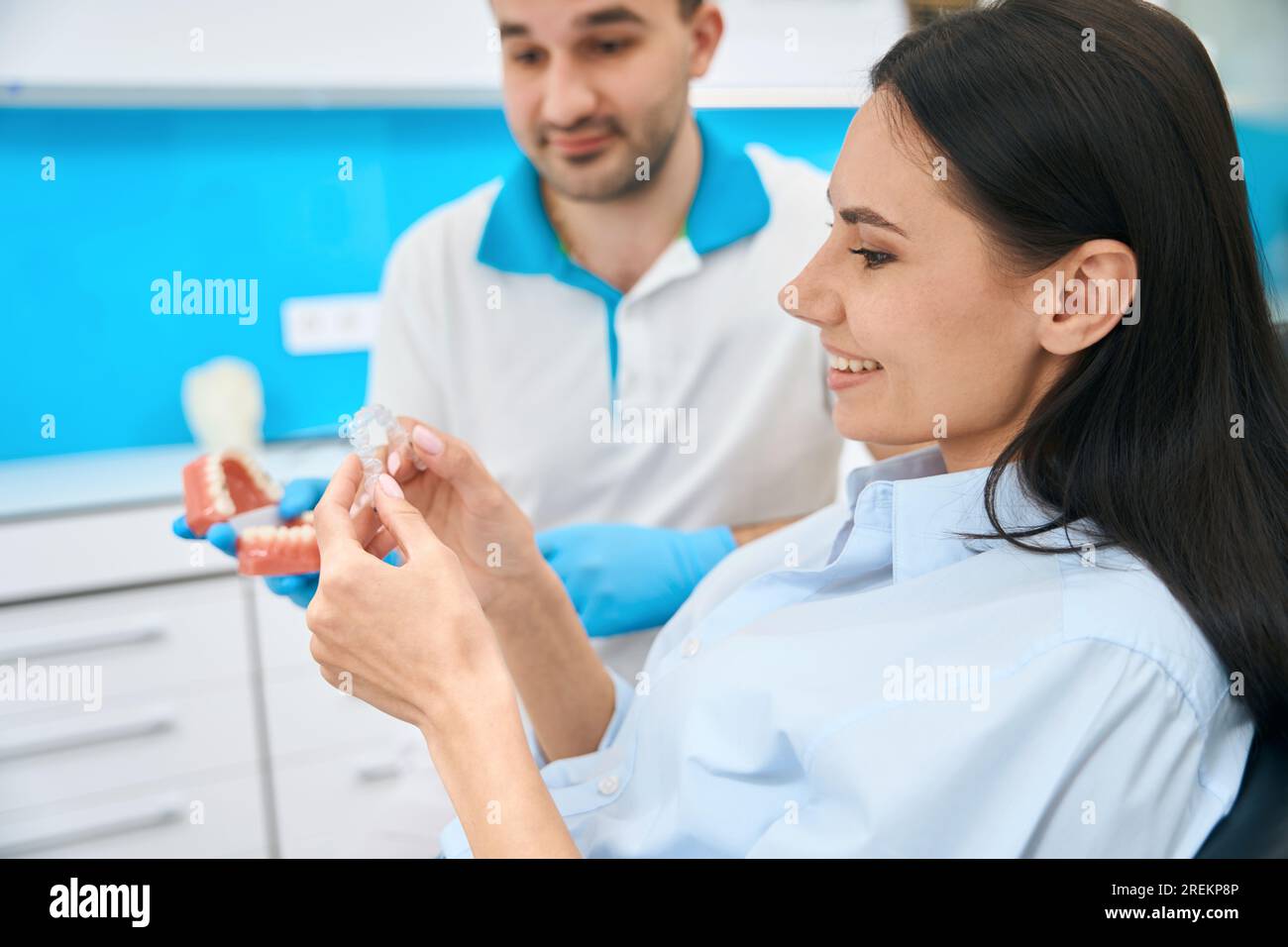 Dentist giving to female patient clear braces that helps to straighten ...