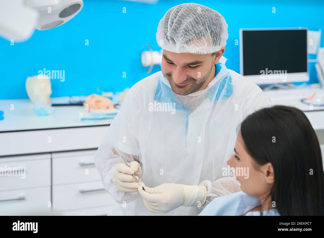High qualified orthodontist explaining to female client teeth treatment ...