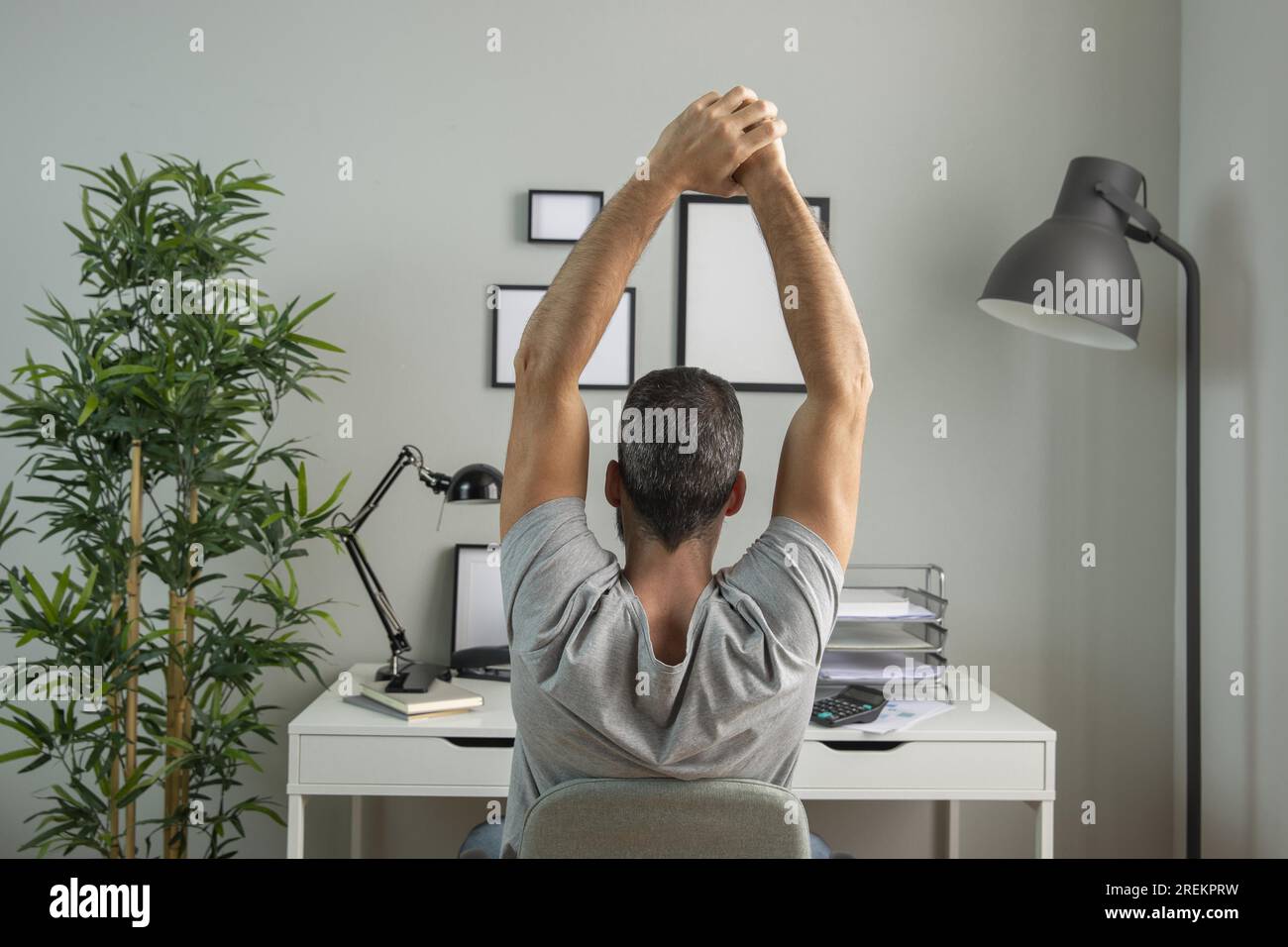 Back view man desk stretching while working from home. Resolution and ...