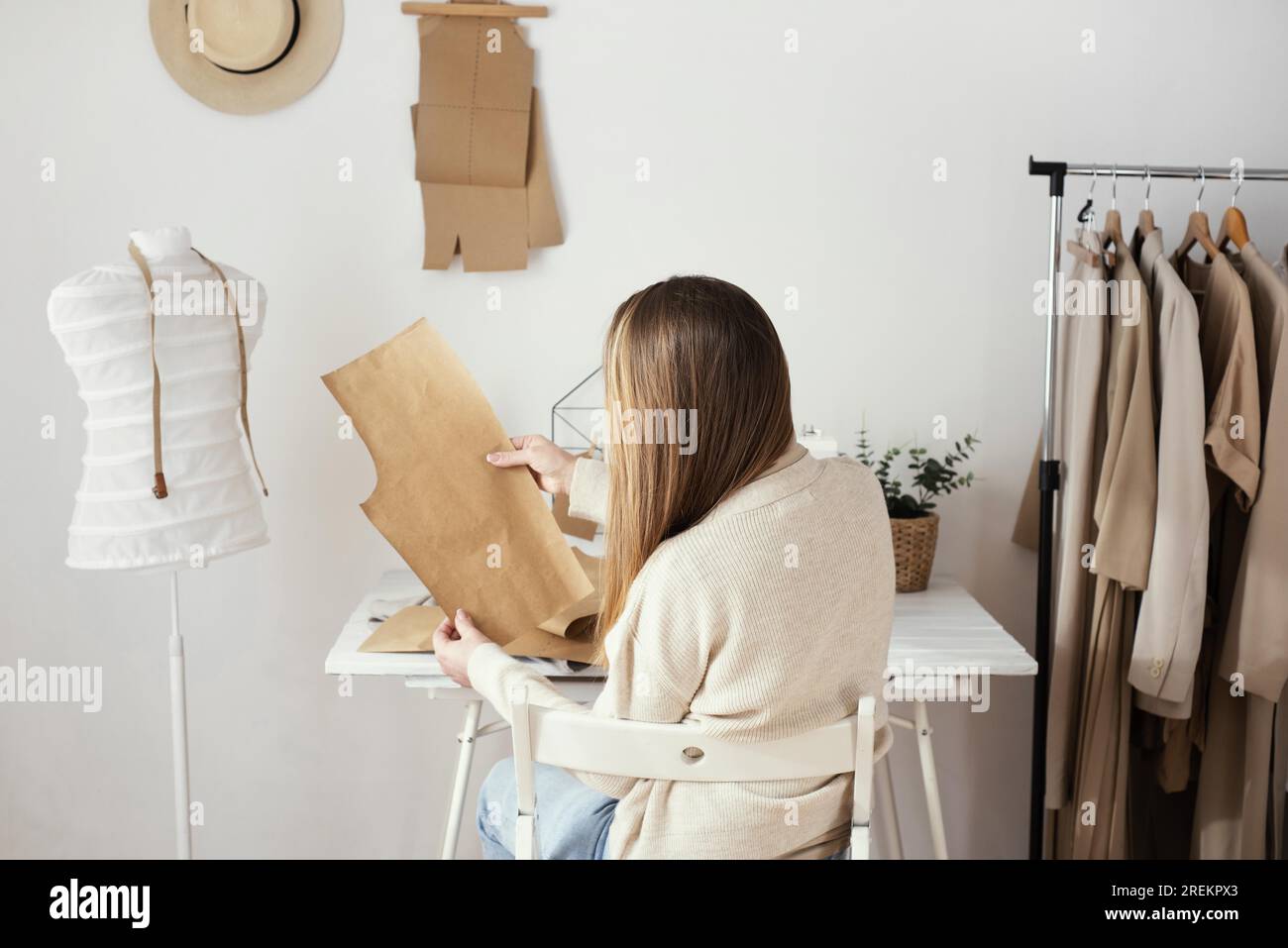 Back view female tailor with patterns hands. Resolution and high ...