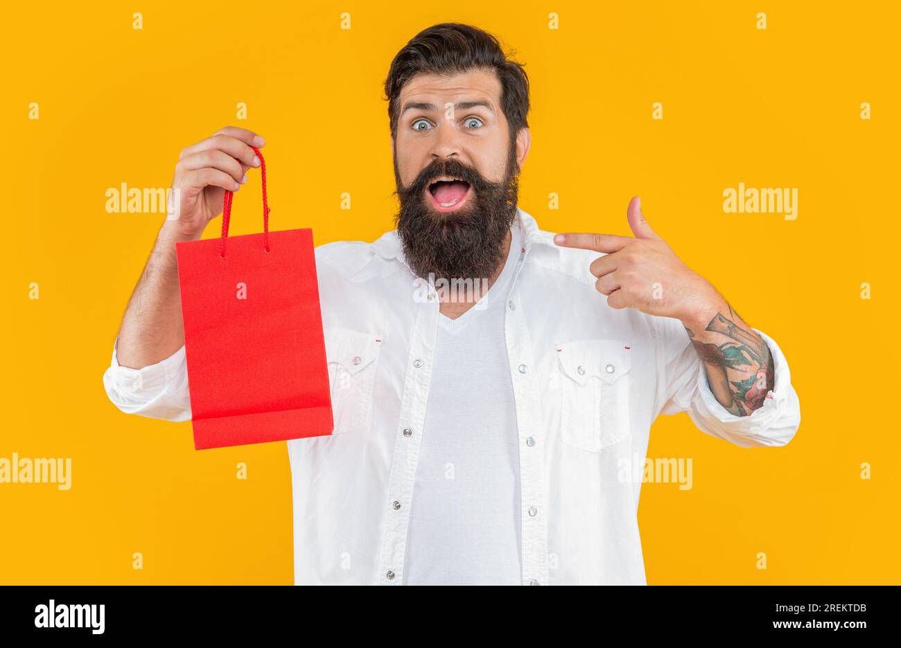 surprised shopper man at shopping in studio, point finger. shopper man ...