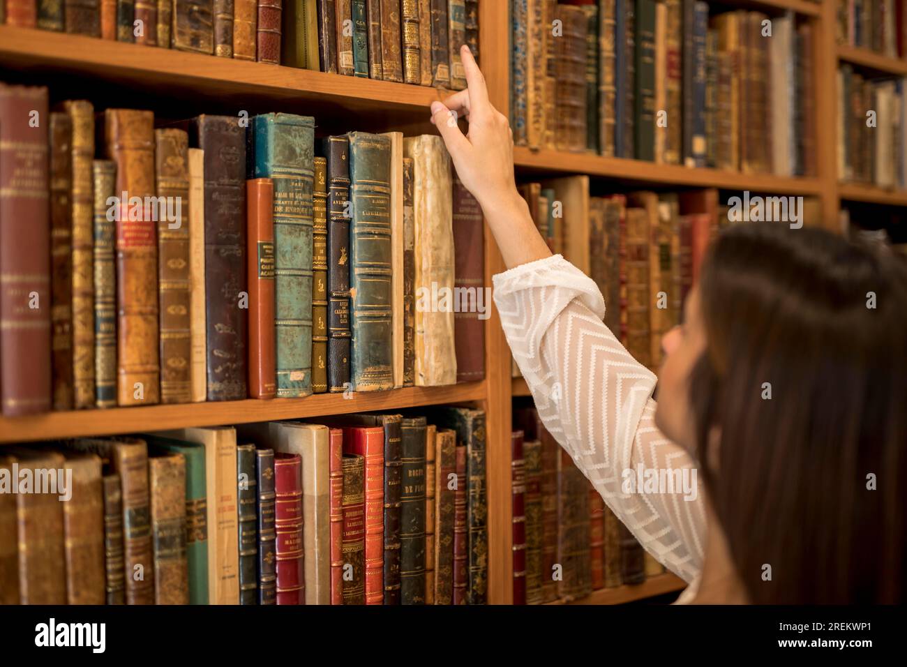 Female choosing book from bookshelf library. Beautiful photo Stock ...