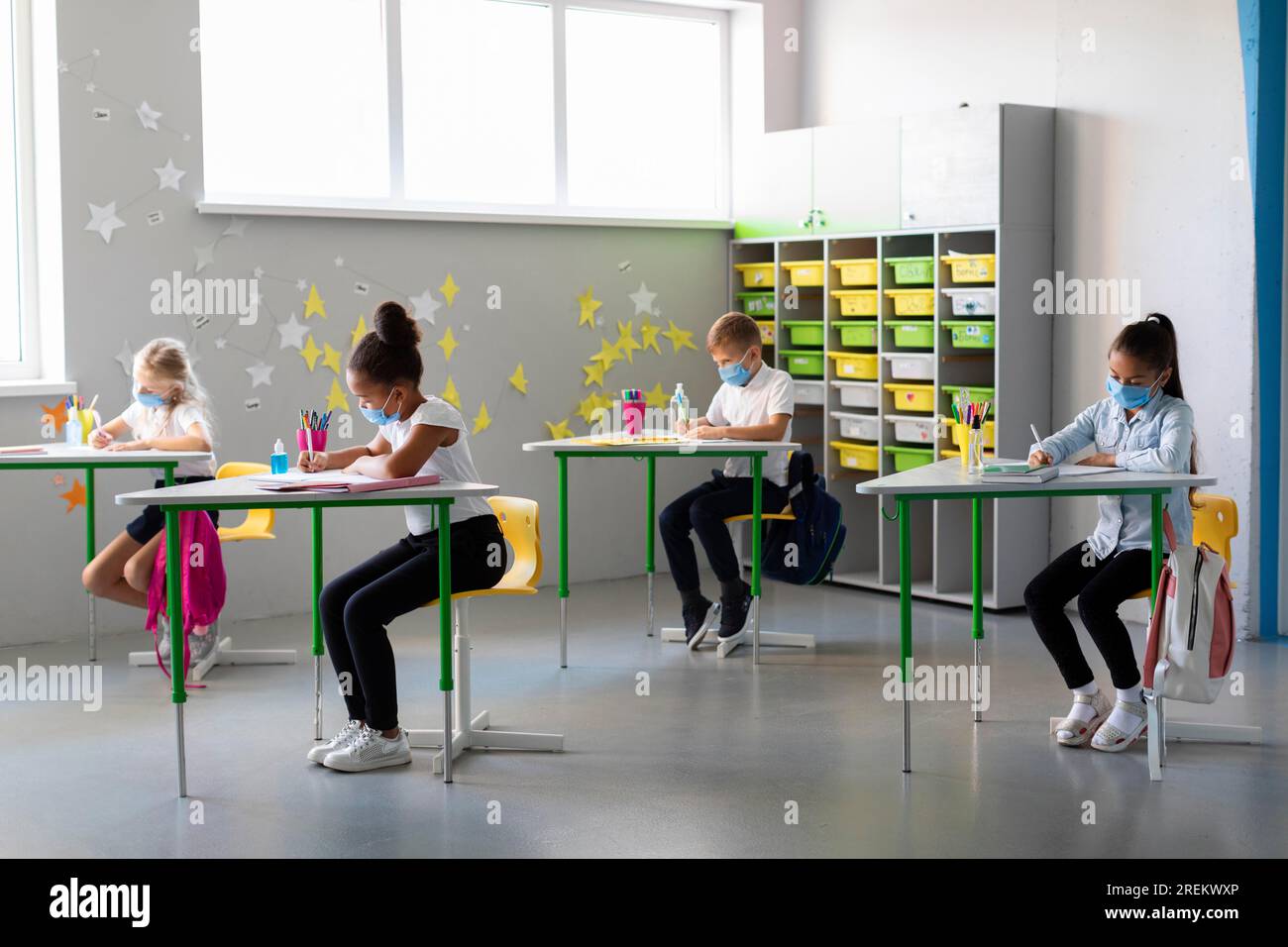 Long shot kids wearing medical masks class Stock Photo - Alamy