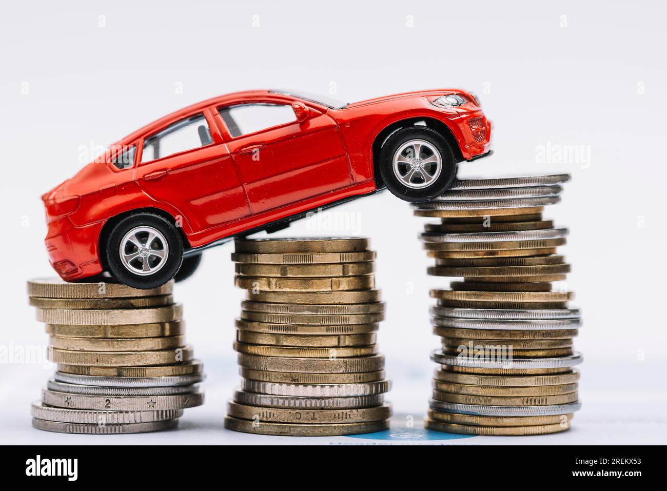 Toy red car stack increasing coins against white background. Beautiful ...
