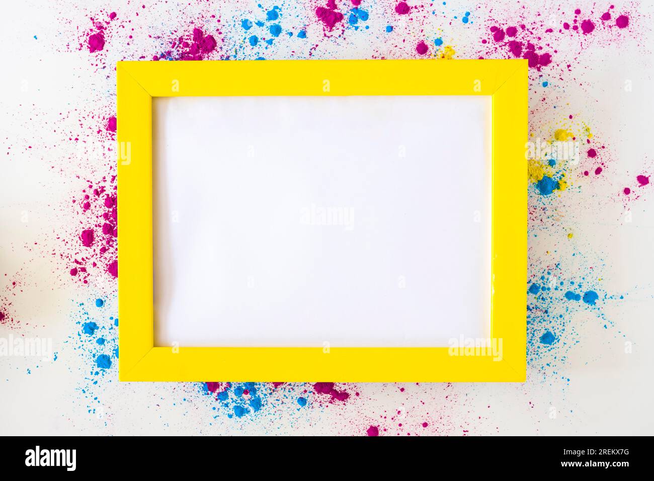 White blank frame with yellow border holi color powder white background ...