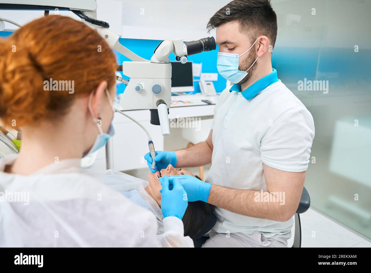 Doctor treats a young female tooth under a microscope Stock Photo - Alamy