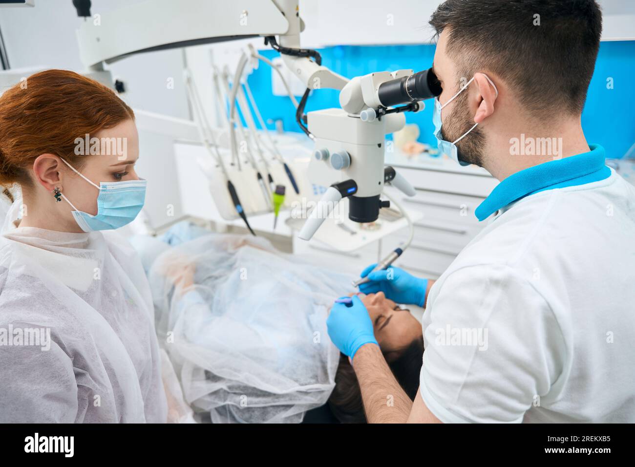 Doctor dentist treats a young female tooth under a microscope Stock ...