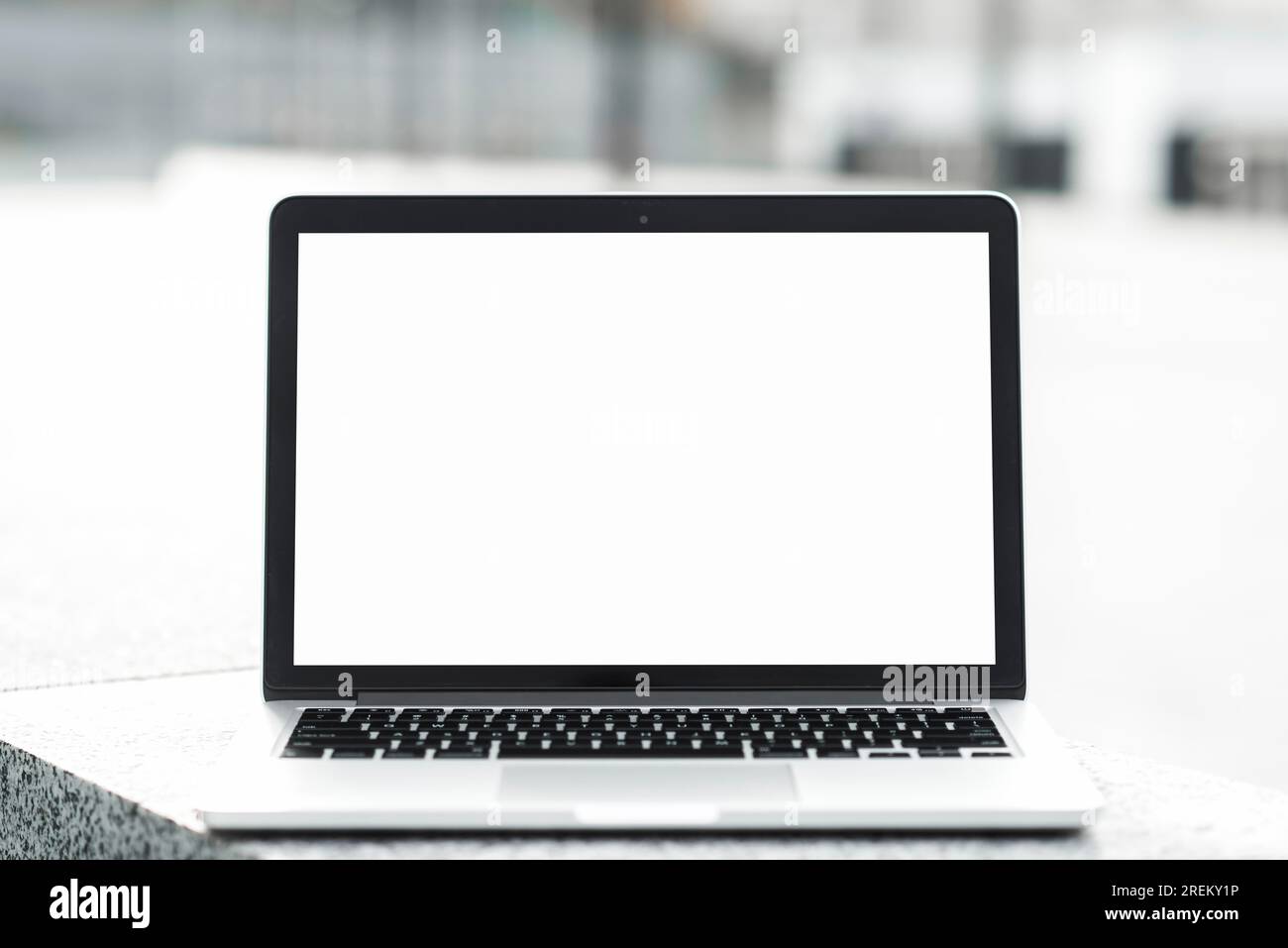 Open laptop showing blank white screen display bench against blurred ...