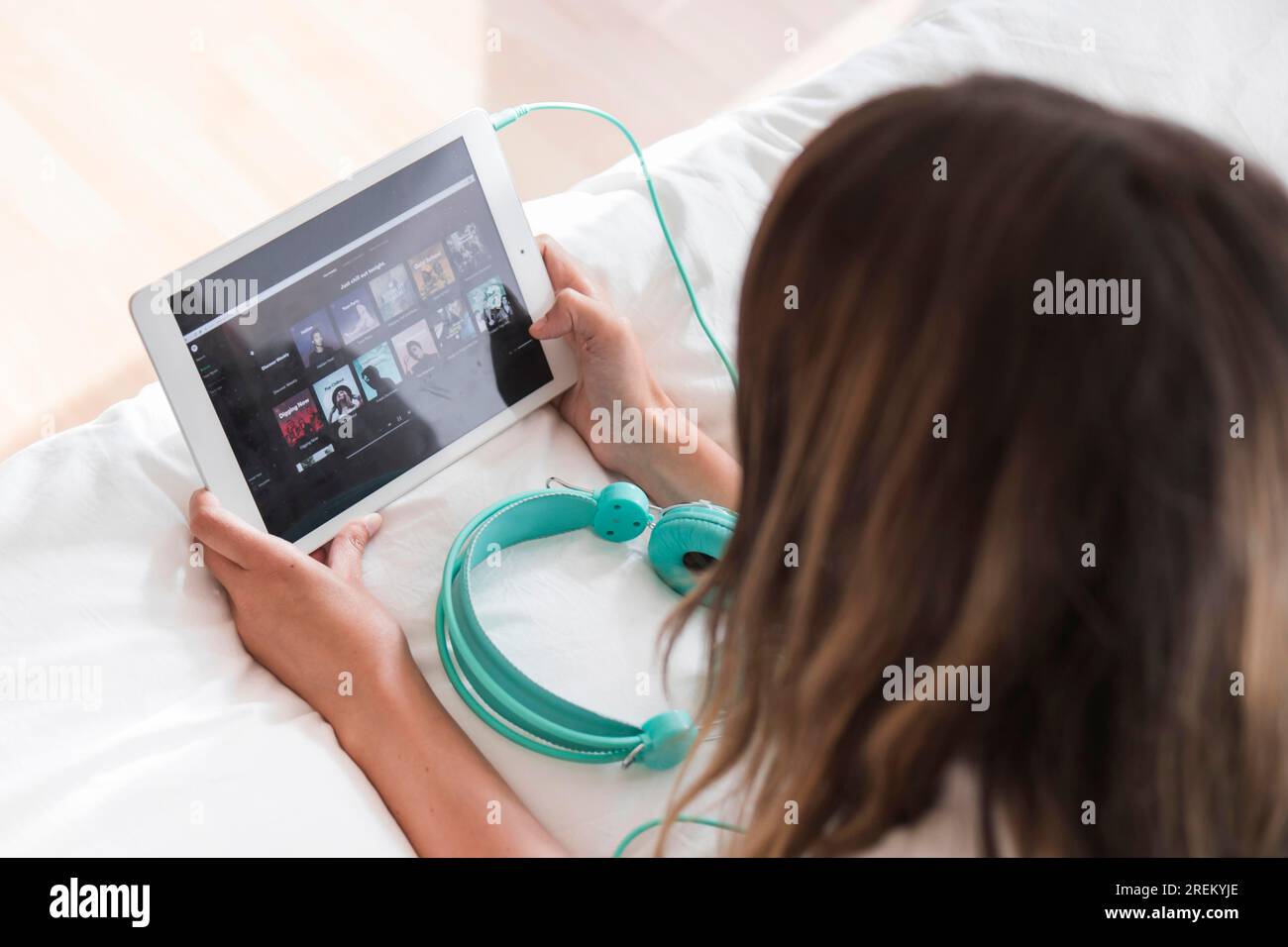 Young woman holding tablet with spotify app. High resolution photo ...