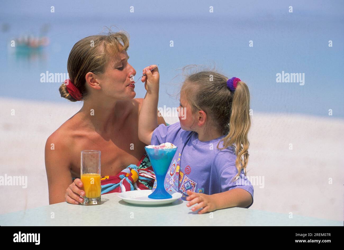 Woman With Girl Mother And Daughter Eating Ice Cream On The Beach