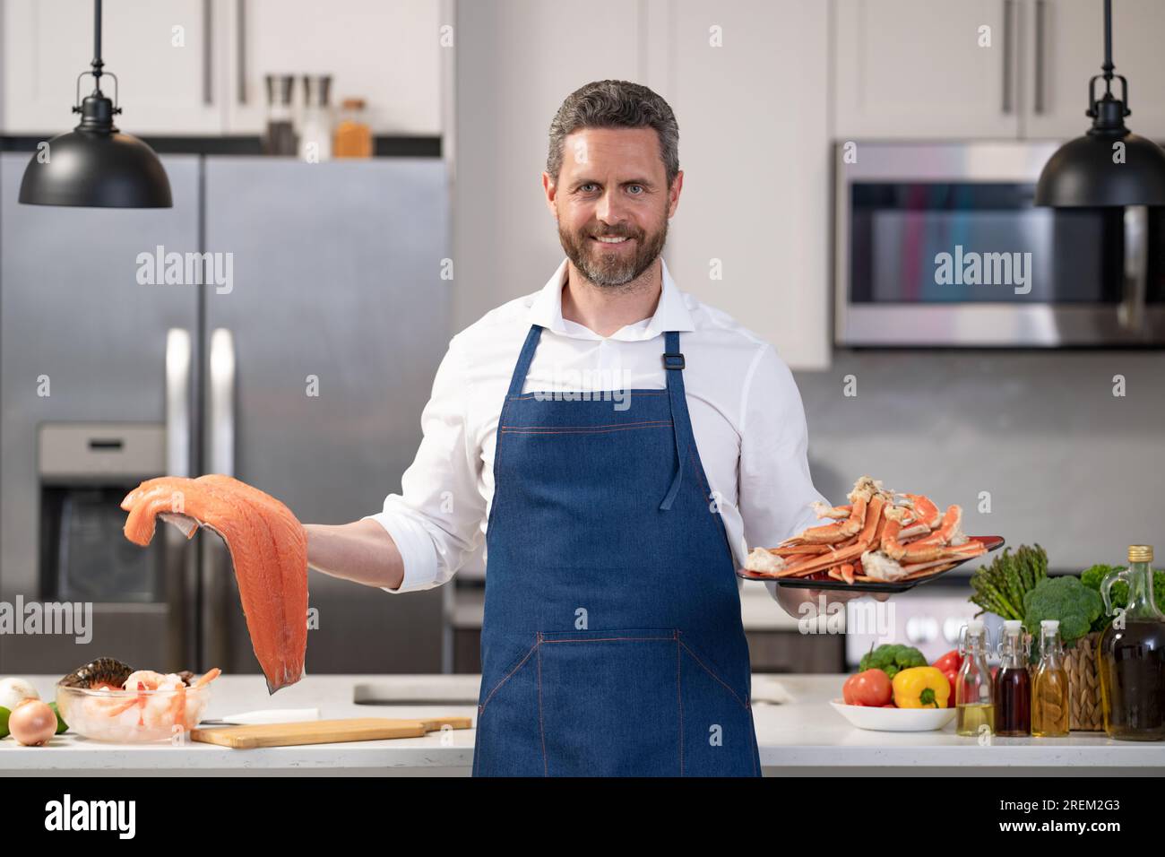 happy chef cooking lobster and salmon seafood. chef with lobster and ...