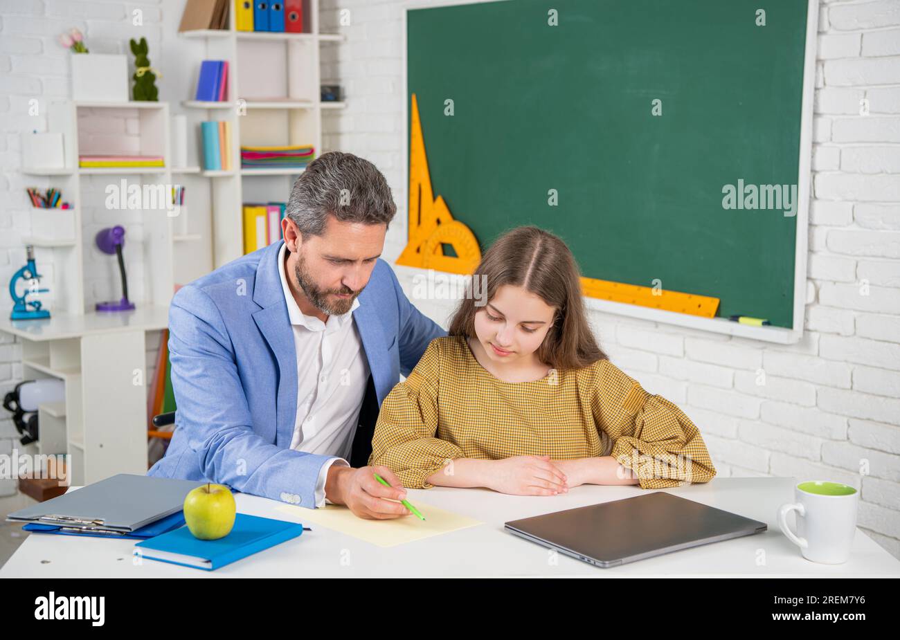 busy child study in classroom with tutor Stock Photo - Alamy