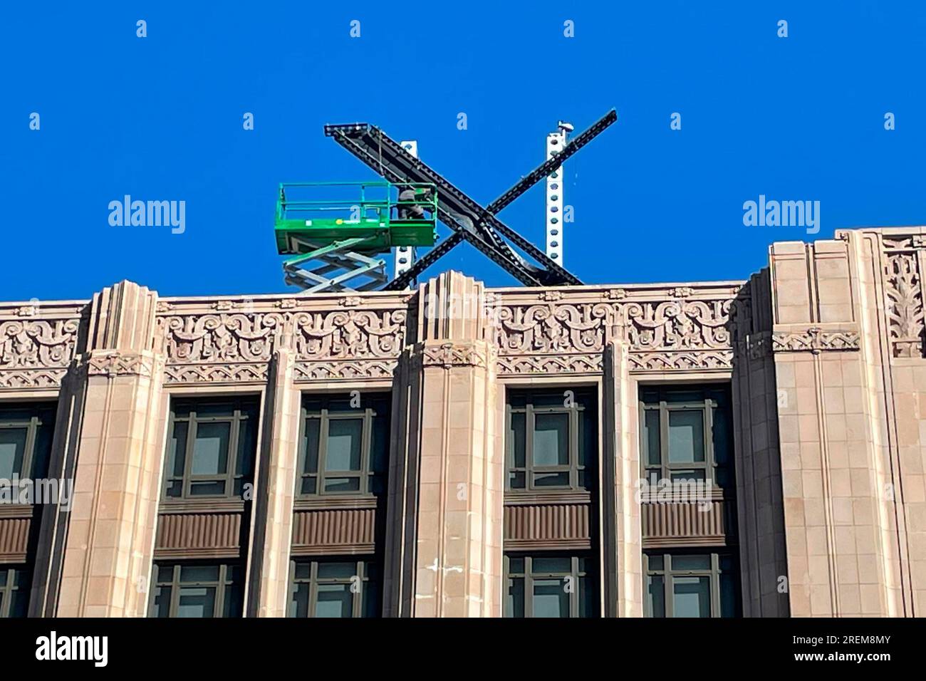 A large, metal "X" sign is seen on top of the downtown building that ...