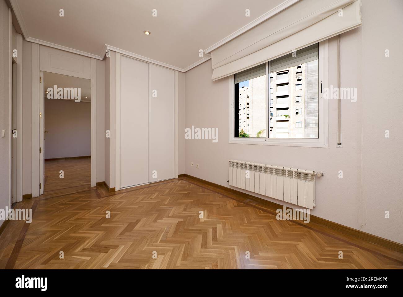 Empty room with a built-in wardrobe with white sliding doors, a large ...