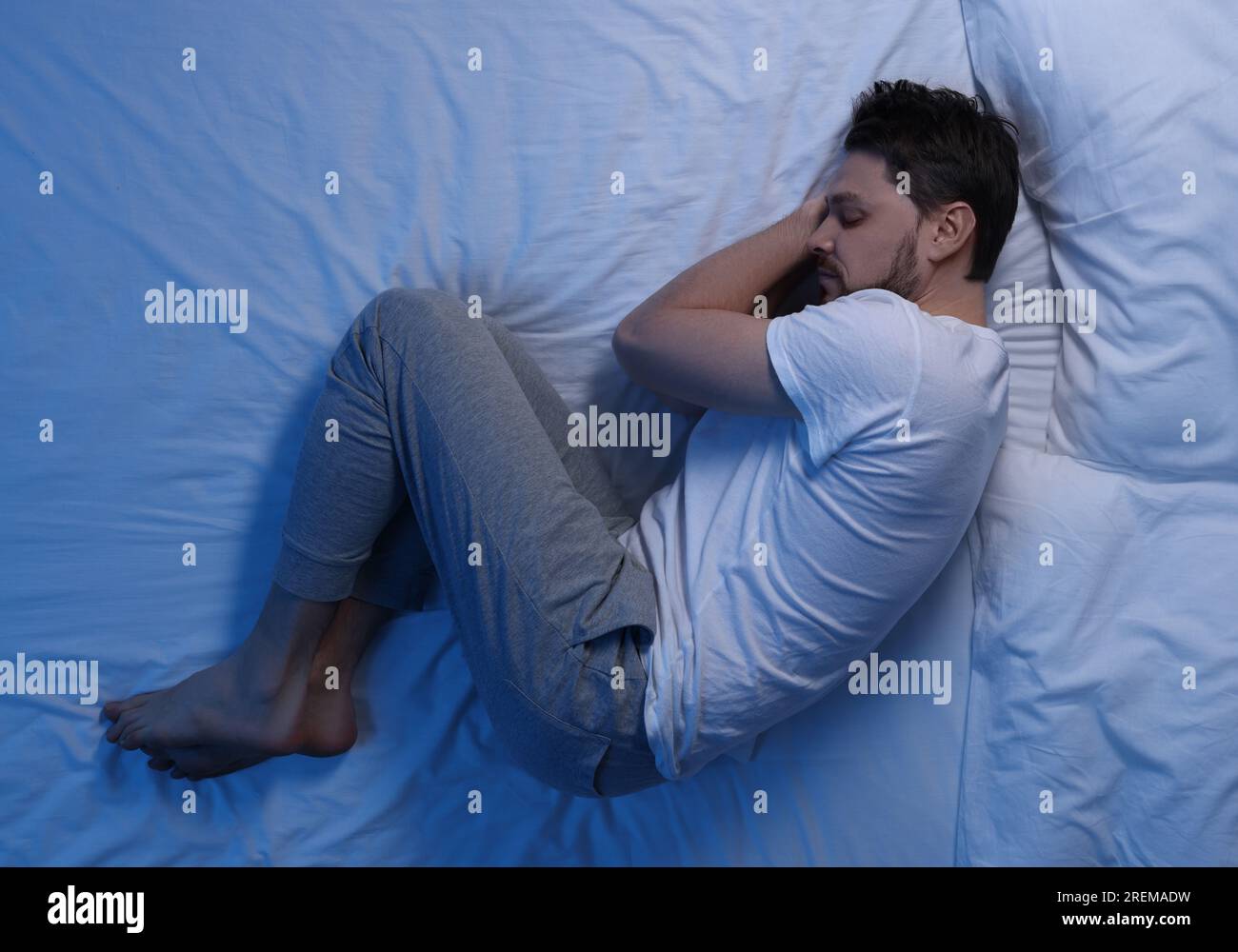 Man sleeping in bed at night, top view Stock Photo - Alamy