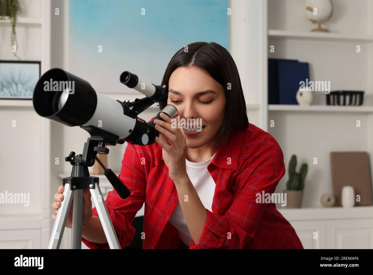 Young woman looking through astronomical hi-res stock photography and images - Alamy