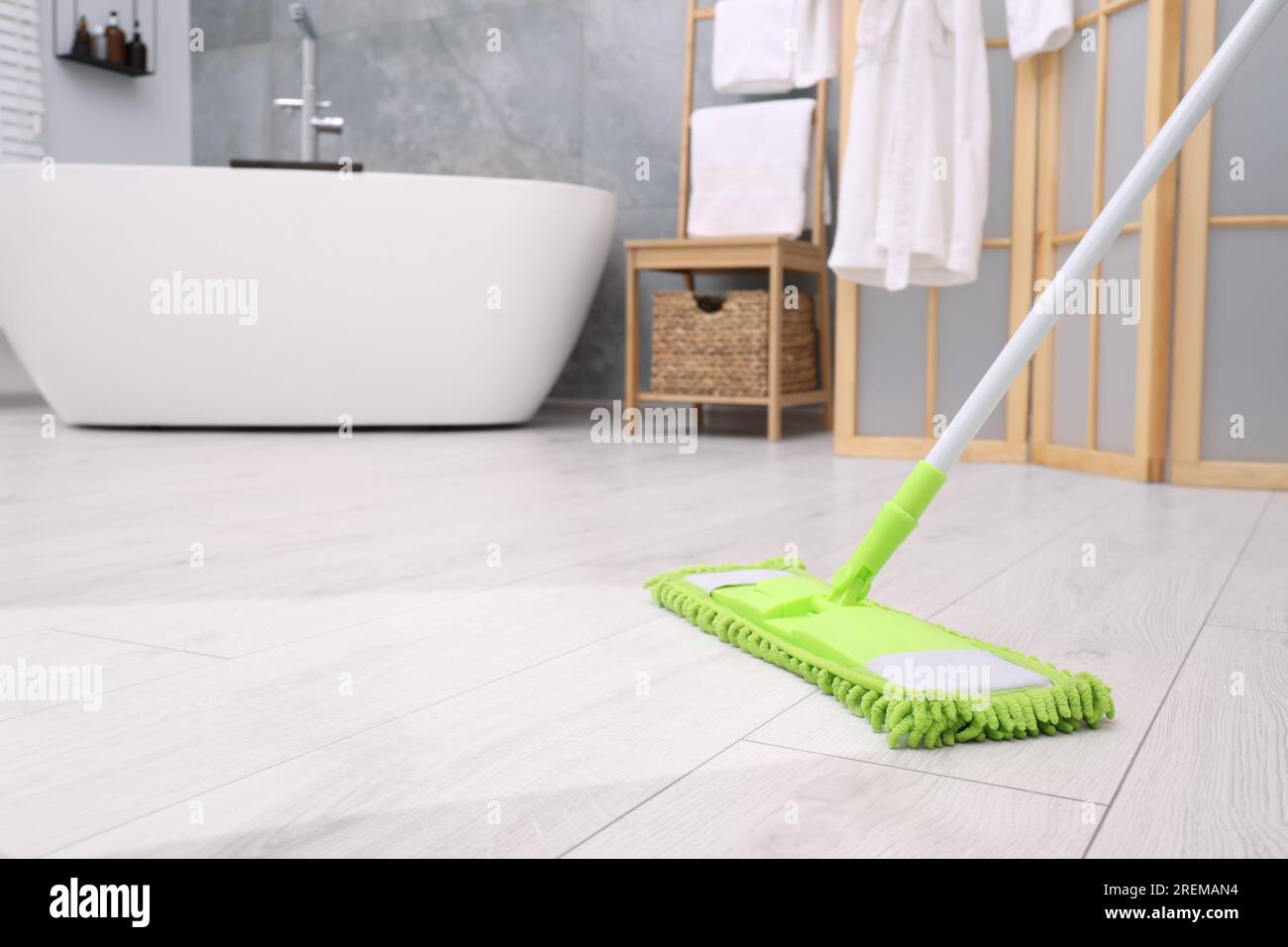 Washing floor with mop in bathroom, space for text. Clean trace on ...