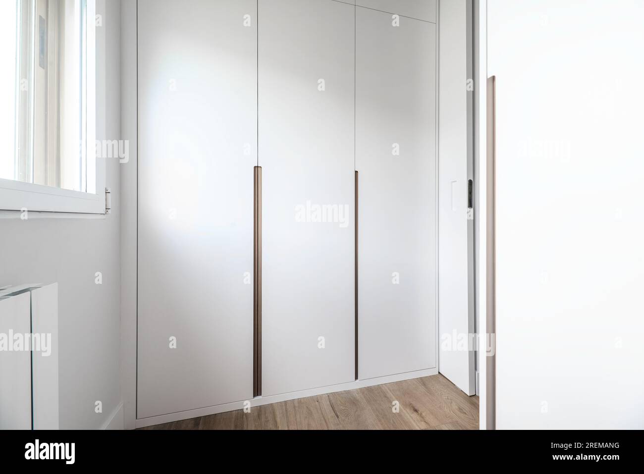 Small walk-in closet with white cabinets with built-in door handles ...