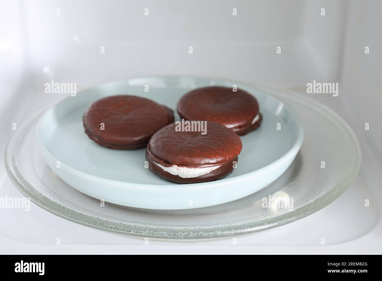 Tasty sweet choco pies on plate in microwave Stock Photo - Alamy